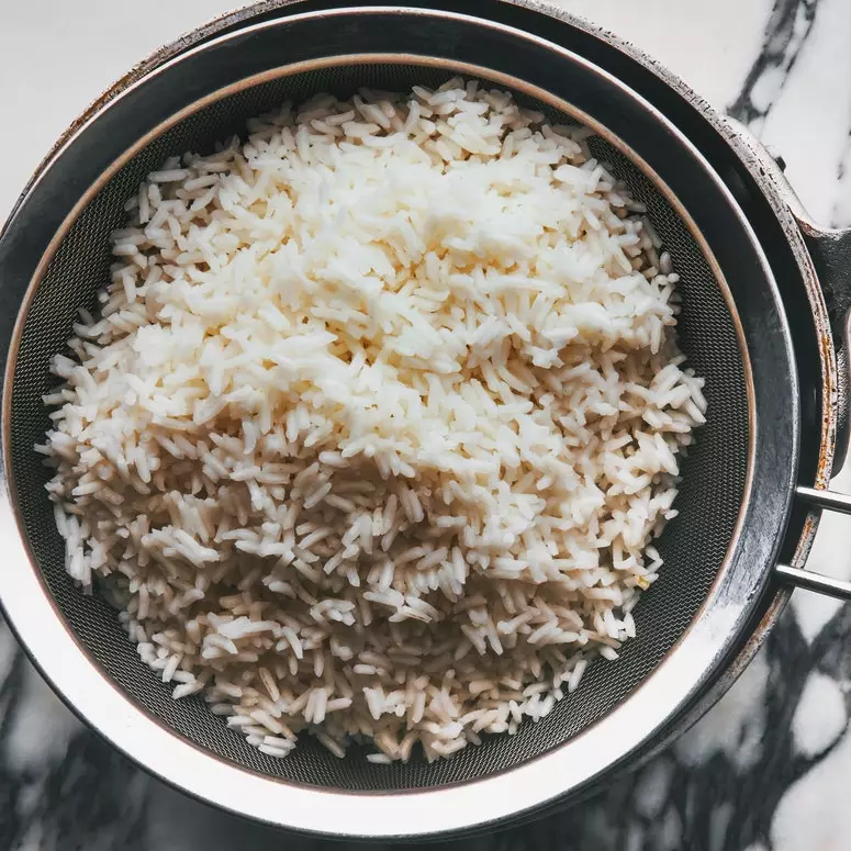 Како да сварите ориз во недела Скријте слика од варен ориз во ситно мрежеста цедалка.