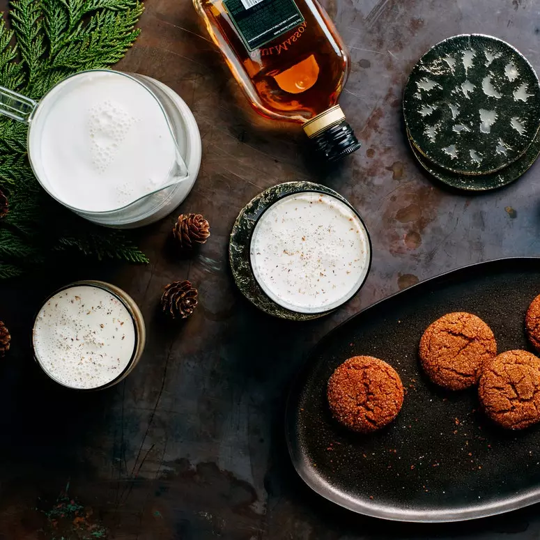 圣诞节的奶油牛奶潘趣酒的照片，戴着眼镜，旁边有一个水罐和一盘饼干。