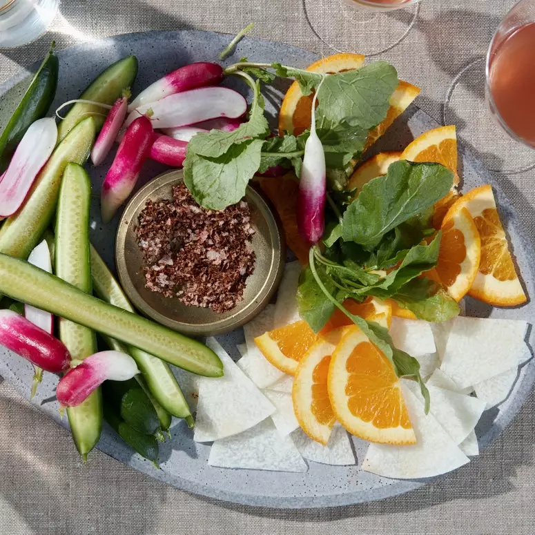 Piring saka irisan cucumbers radishes jicama lan jeruk karo Bowl saka uyah chili jeruk.