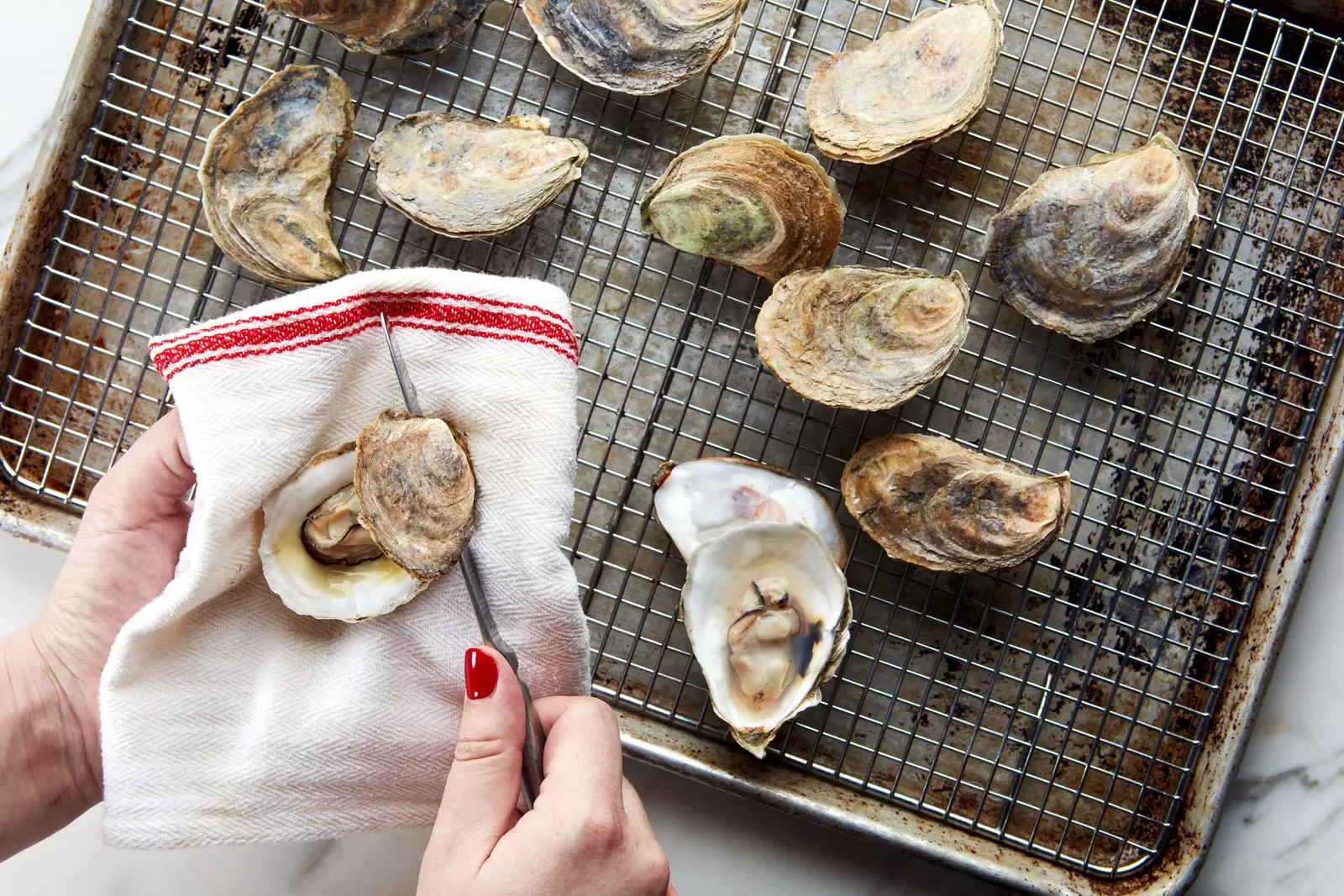 Larawan ng isang sheet pan ng oven na nag-pop oyster para kainin sa kalahating shell o gamitin para sa recipe ng oyster stuffing.