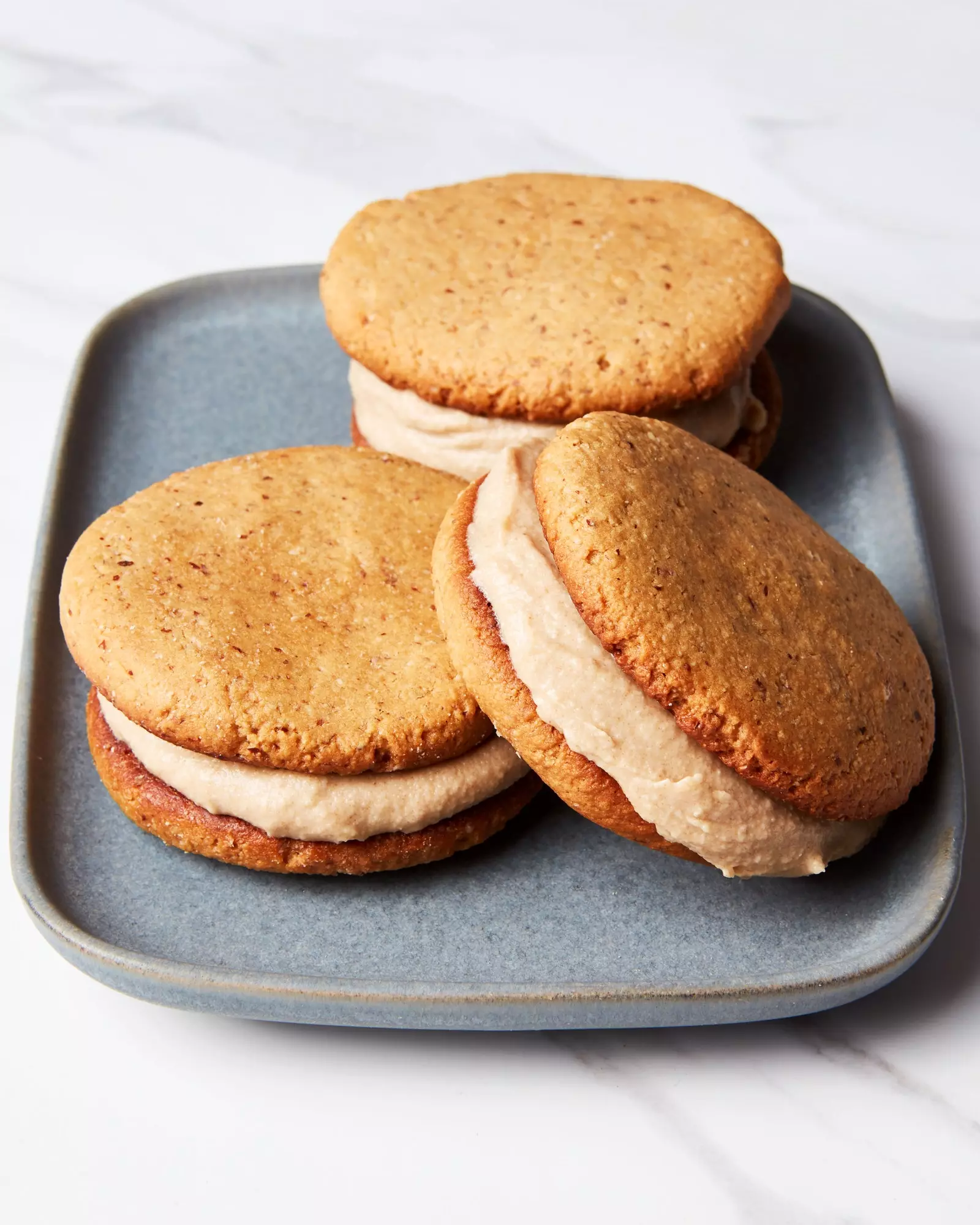 Ifoto ya Peanut Butter Coconut Cream Sandwich Cookies ku isahani.