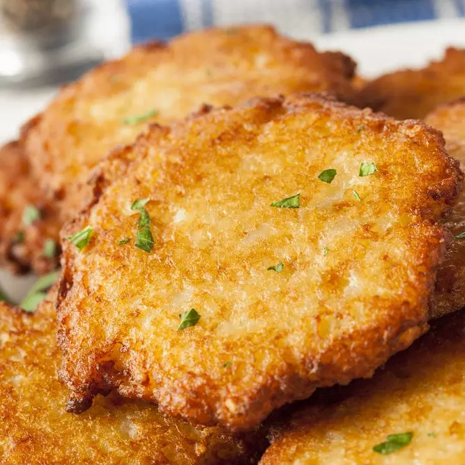 Latkes nó pancóga prátaí ar phláta le garnish peirsil.