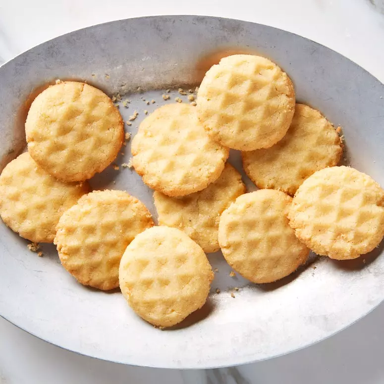 Foto de galletas de arroz iraníes con impresiones hechas con un mazo de carne en una fuente para servir.