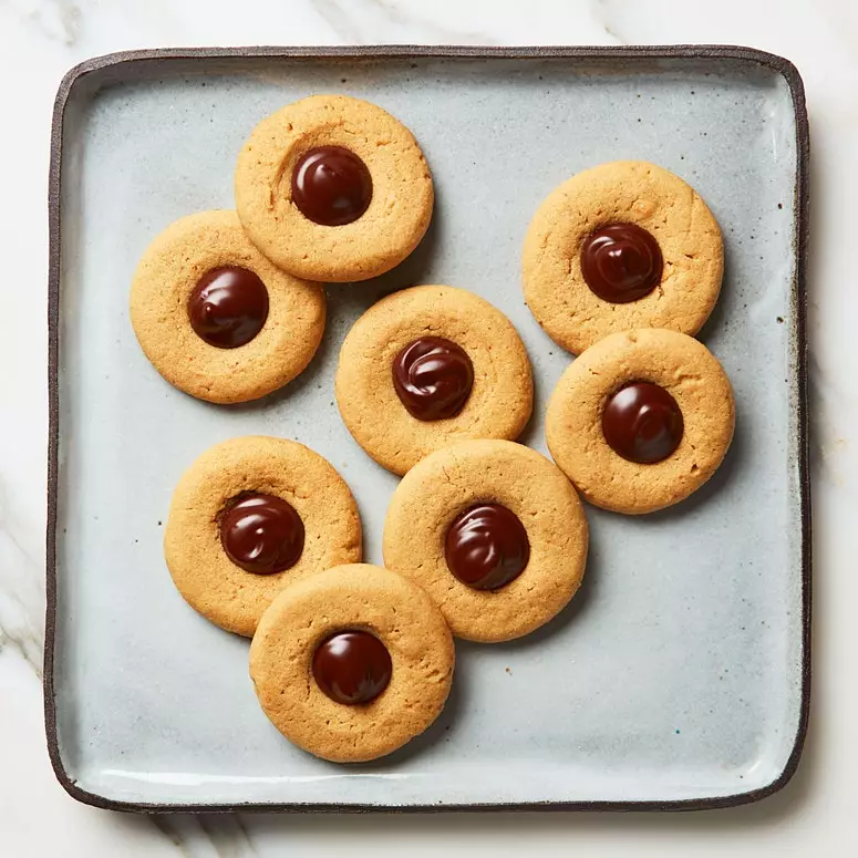 Foto van pindakaasbloesemkoekjes met chocoladeganache in het midden.