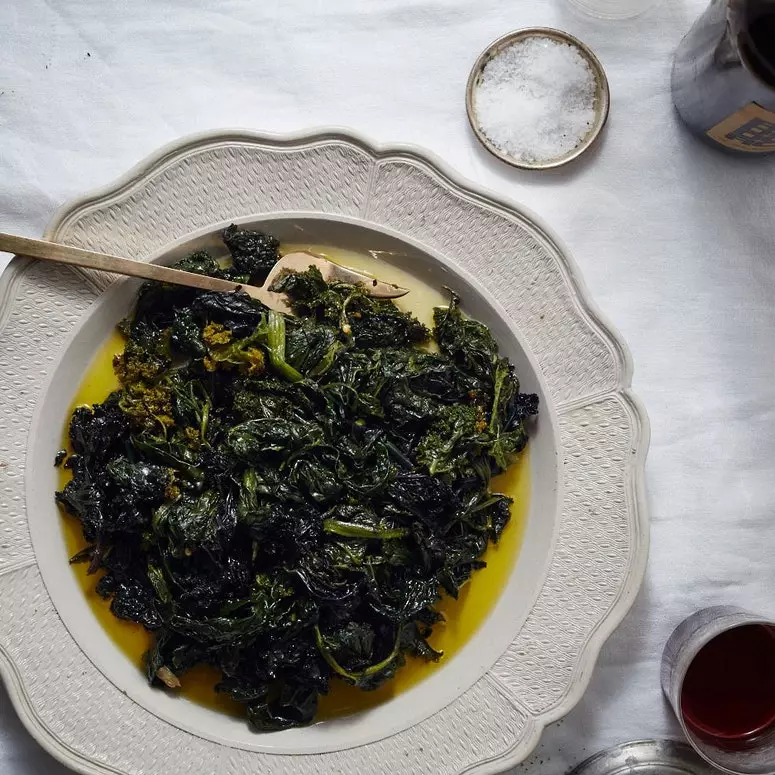 Slowcooked garlicky greens yn olive-oalje op in plaat.