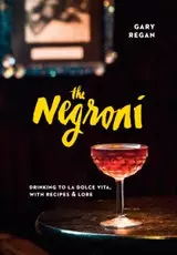 Naslovnica knjige Negroni s fotografijom čaše za koktel s peteljkom na crnom stolu.