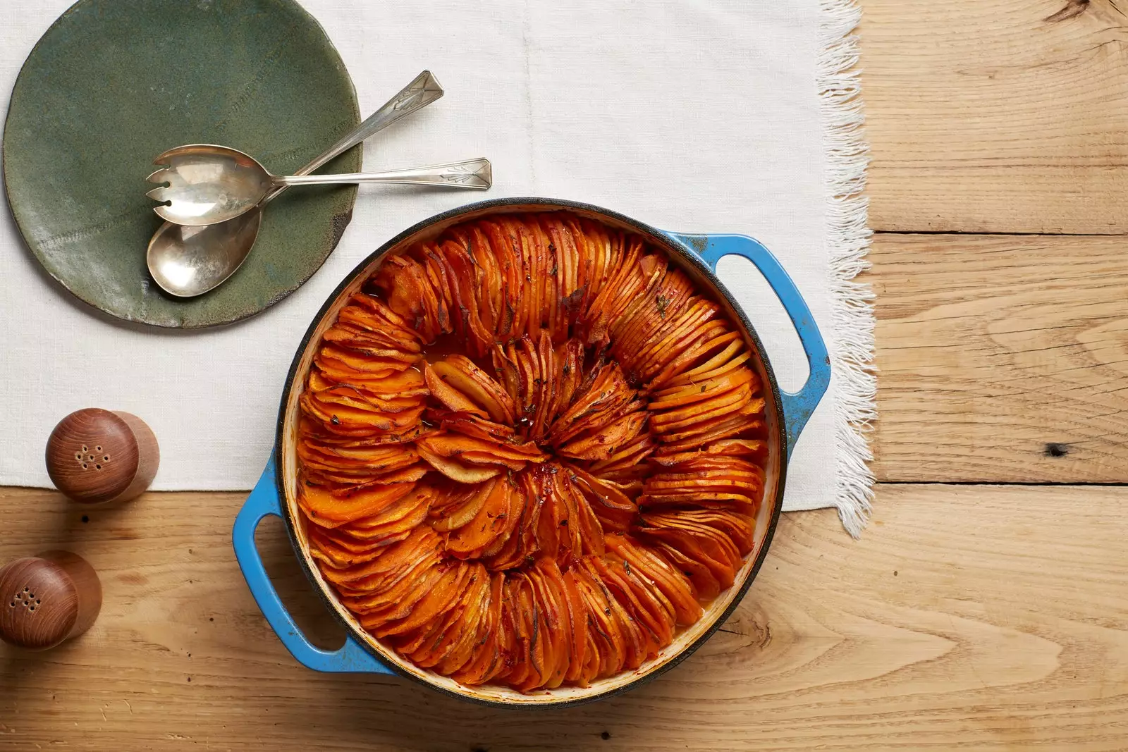 Rodajas delgadas de camote dispuestas verticalmente en un horno holandés pesado.