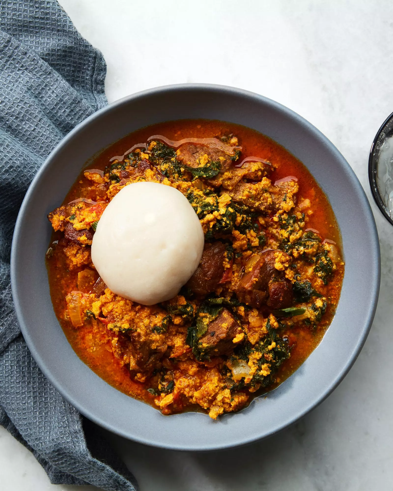 Foto van Nigeriese Egusi-bredie saam met Fufu.