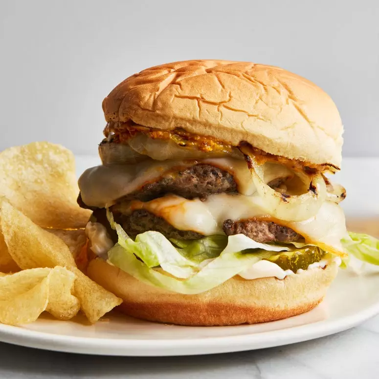 Photo d'un hamburger aux champignons et au poulet double empilé.