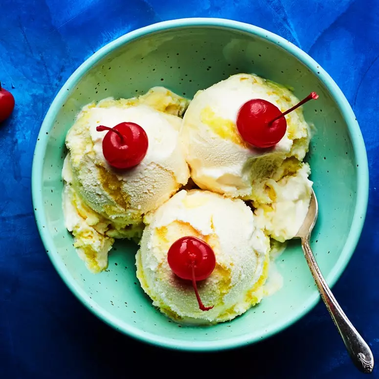 receita fácil de sorvete para sobremesa feita com sorvete de coco comprado em uma tigela turquesa com cerejas no topo